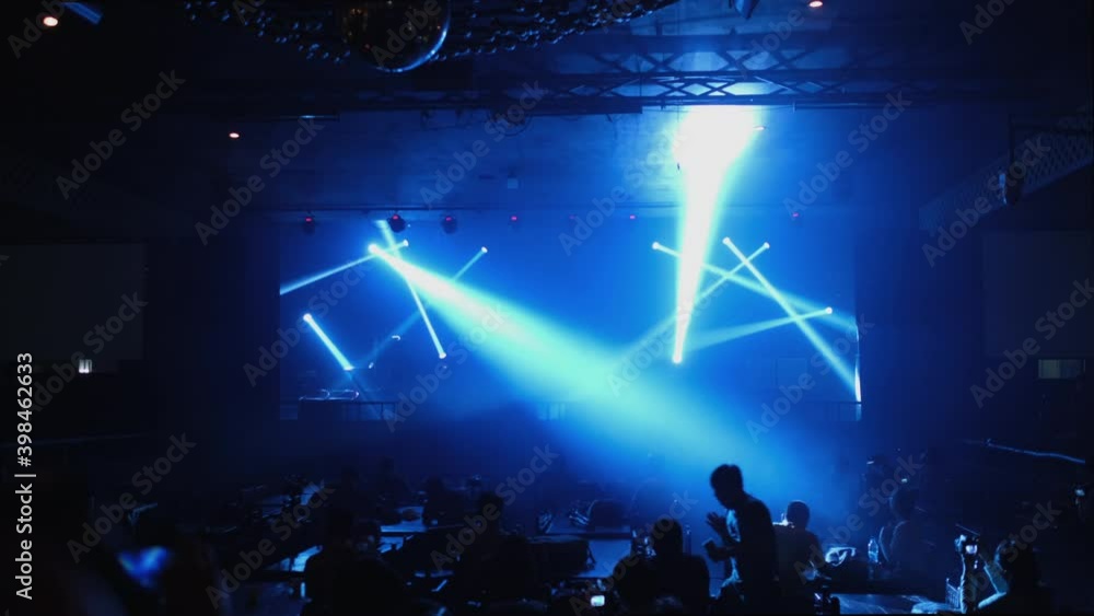 Illuminated empty blue concert stage with fog and rays of light in the ...