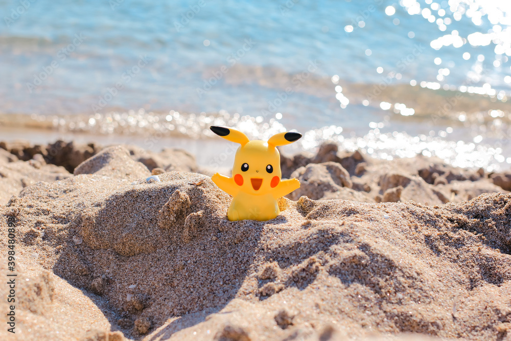 Pikachu figure model sitting on a sandy beach by the sea. Stock Photo ...