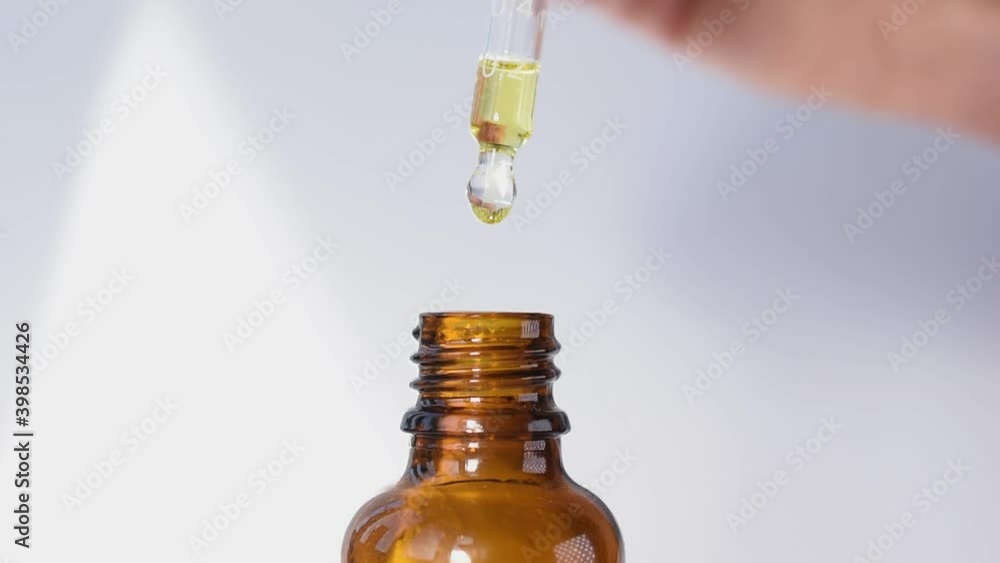 A pipette / dropper dispensing a drop of solution / medicine / vitamin ...
