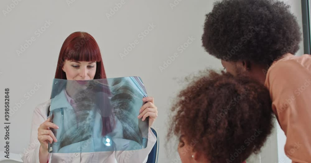 Female pediatrician holding a lung x-ray in her hands. The doctor ...