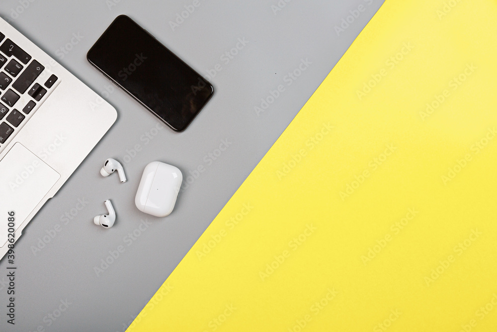 Desktop flat lay with laptop, mobile phone, wireless headphones. Colors ...