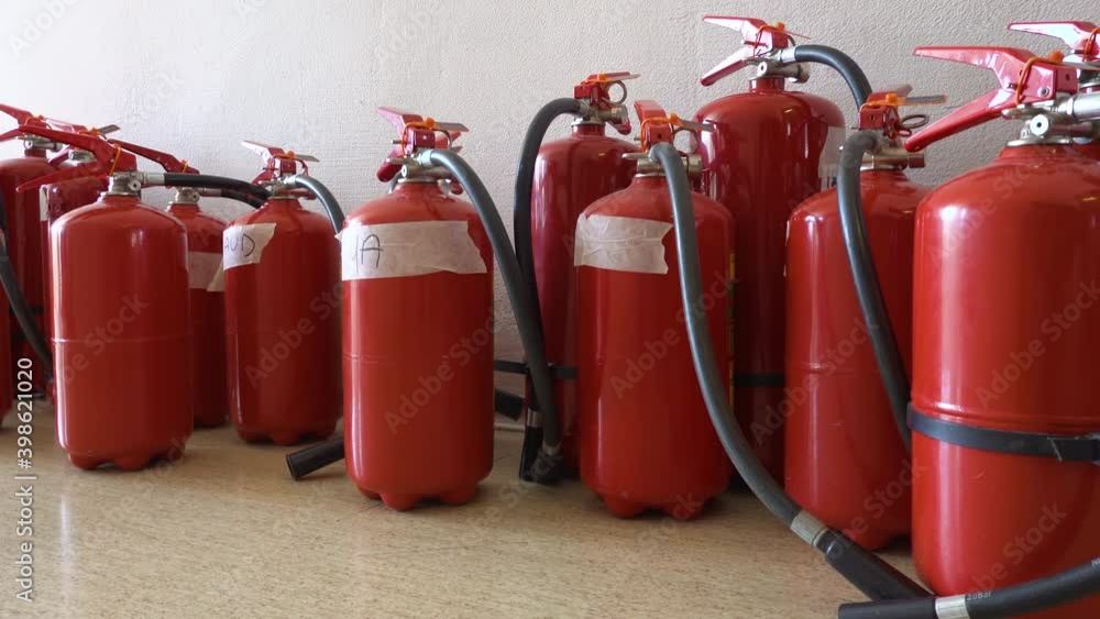 Bunch of expired fire extinguishers on the floor next to the wall ...
