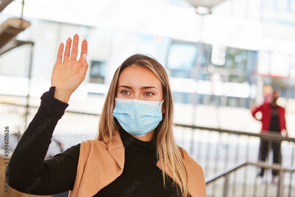 Waving woman as a passer-by with face mask in the city Stock Photo ...