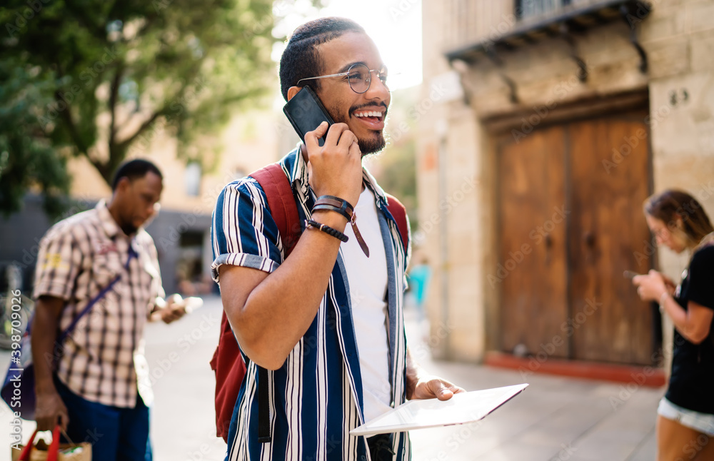 Happy dark skinned 20s male tourist in casual wear laughing during ...