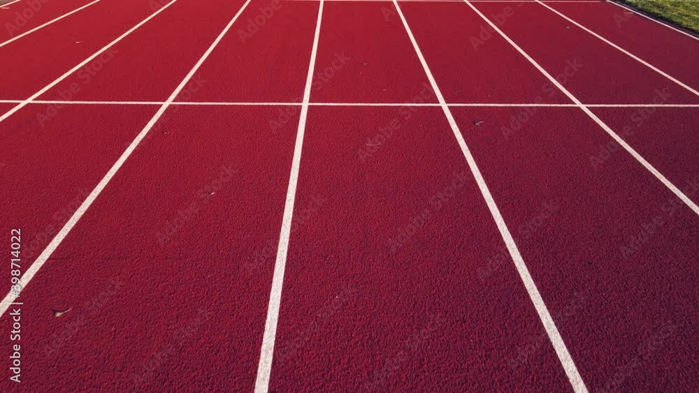Aerial footage of running track in a sport stadium. first person view ...
