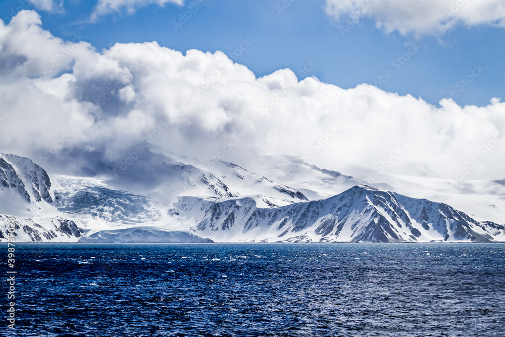 Sharp peaks and ridges covered in deep snow and soft clouds Stock Photo ...