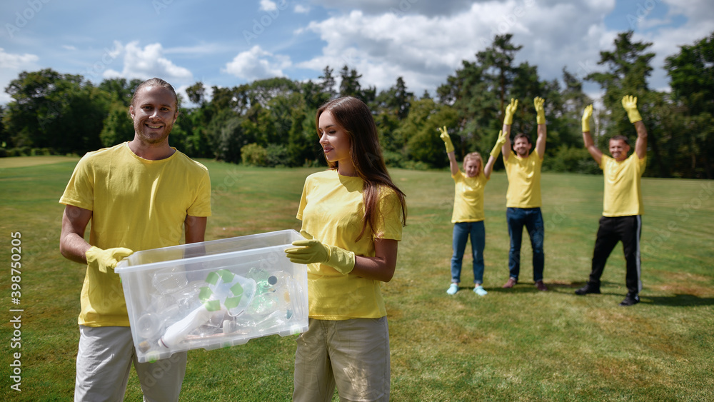 Plastic pollution. Two young eco activists wearing uniform holding a ...