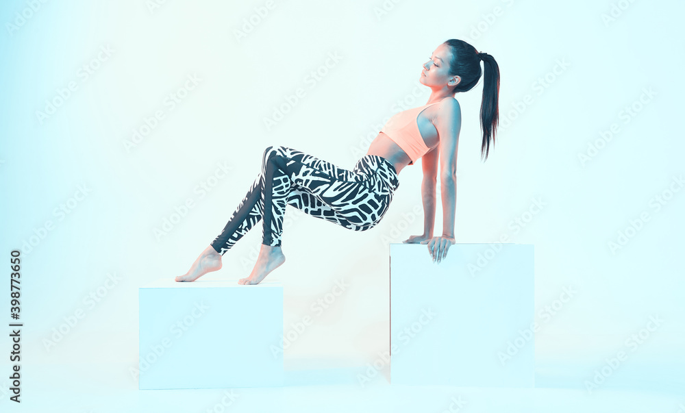 Sporty girl posing in sport clothes in neon light. Fit young model with ...