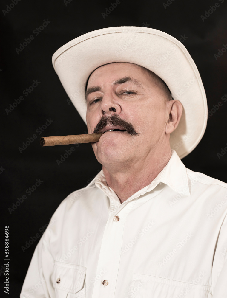 The cowboy with mustache in a white hat, smoking a cigar Stock Photo ...