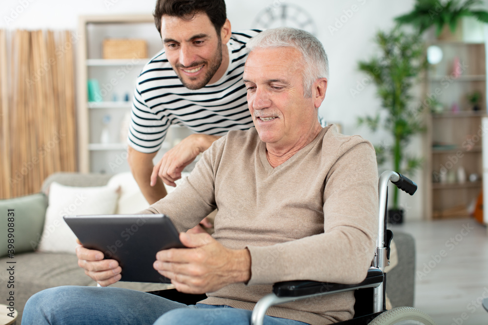 handsome man taking care about his eldery father in wheelchair Stock ...