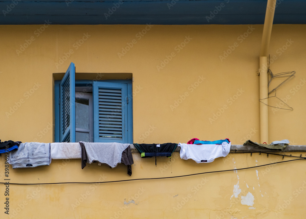 Clothes hanging on the balcony in front of the window of a traditional ...