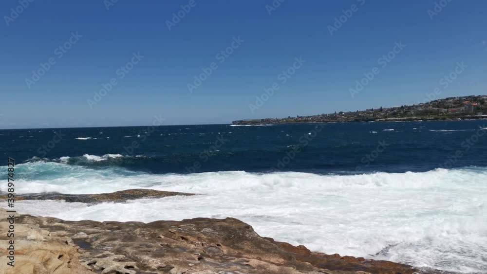 Beautiful coastal trail lookout with deep blue sky, big splashing ocean ...