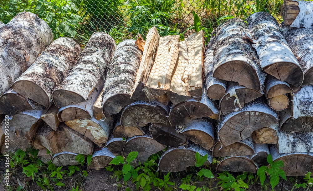 Split birch wood stacked in a woodpile against the background of ...