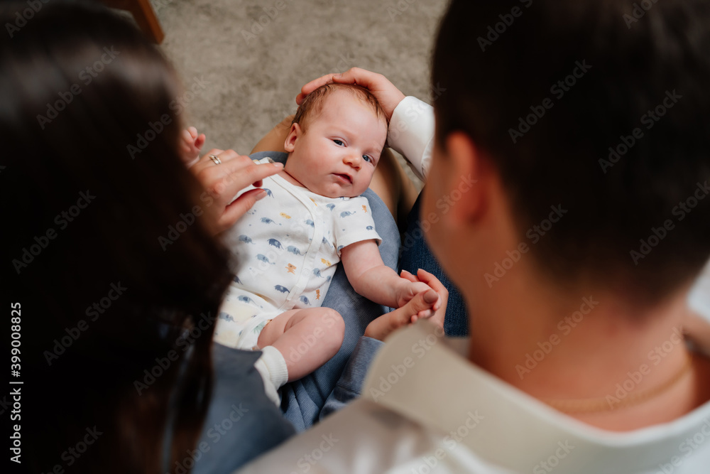 top view. shooting over shoulder. newborn baby is lying on lap of his ...