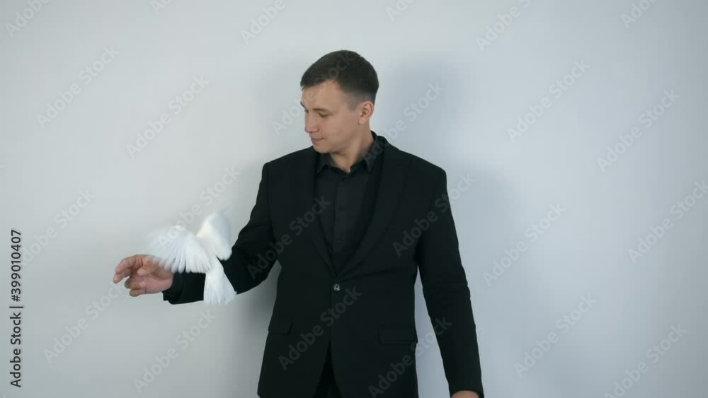 Illusionist in black suit is doing trick with animal in slow motion ...