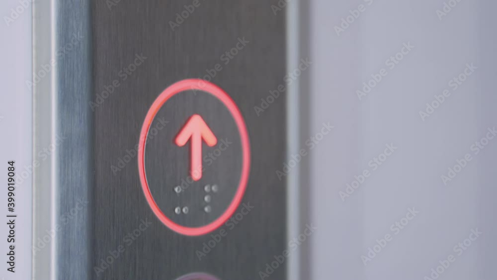 Woman finger pressing elevator up button on lift control panel at mall ...
