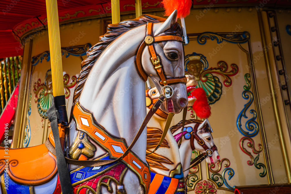 Old French carousel in a holiday park. Three horses and airplane on a ...