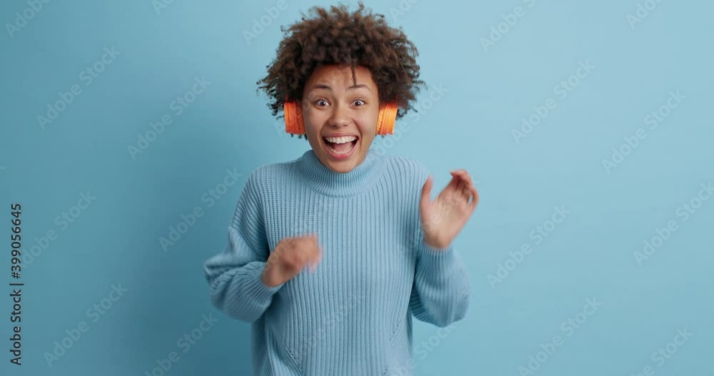 Optimstic successful dark skinned young woman hears awesome track in ...