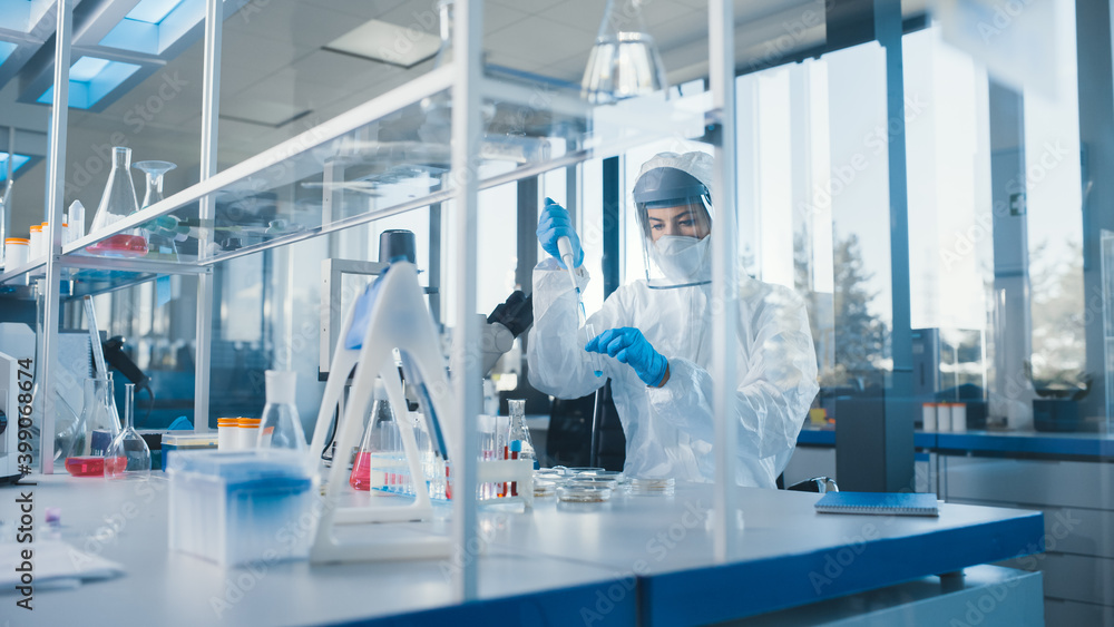 Beautiful Female Medical Scientist Wearing Coverall and Face Mask Using ...