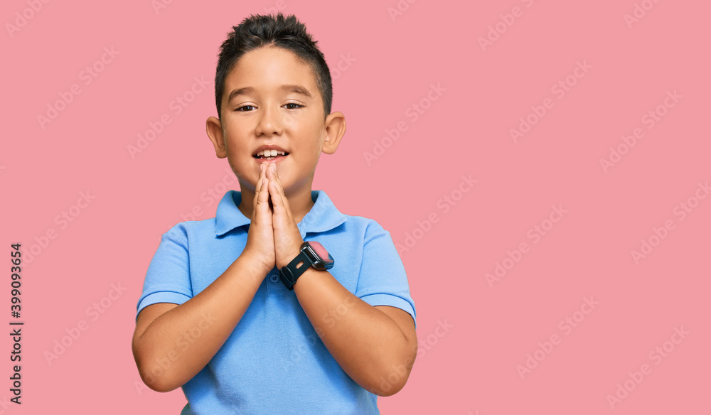 Little boy hispanic kid wearing casual clothes praying with hands ...
