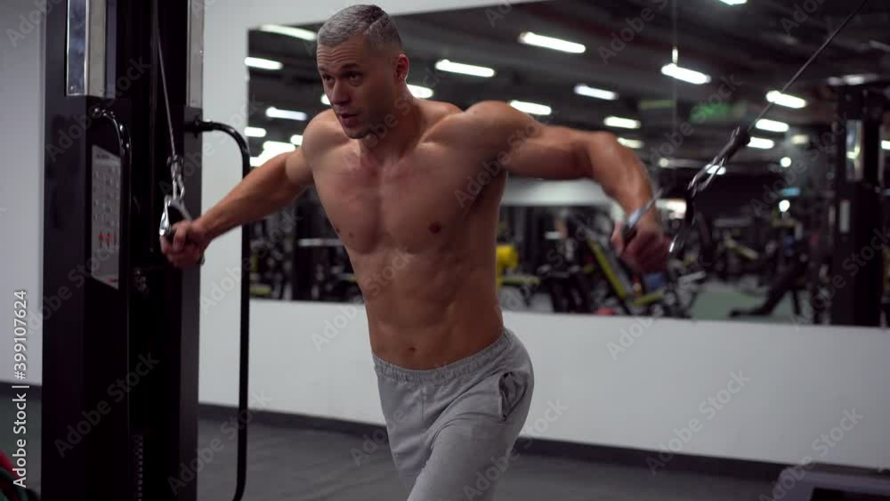 Muscular athletic bodybuilder standing training chest and shoulders ...