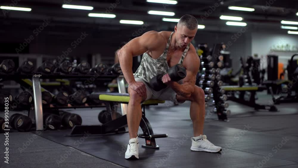 Muscular athletic bodybuilder fitness model sitting bench training ...