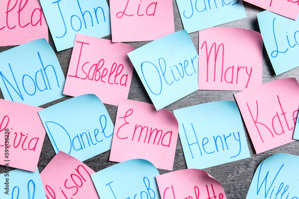 Paper notes with different baby names on grey background, flat lay ...