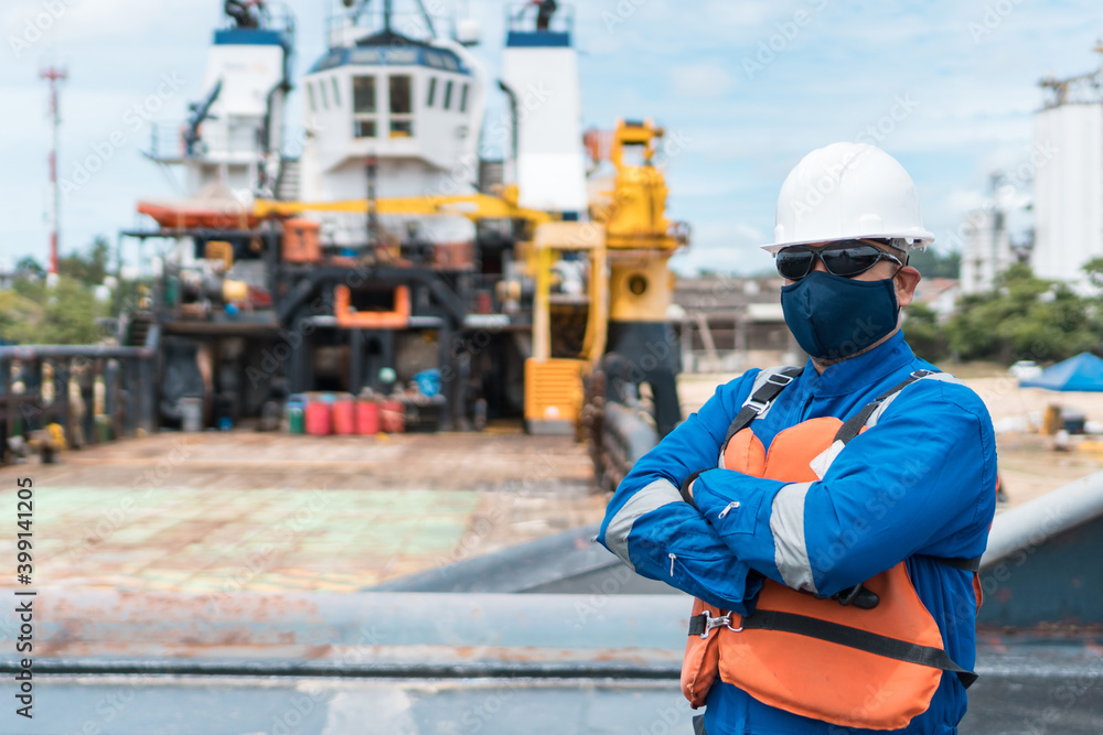 Deck officer with protective mask on ship deck, with PPE personal ...
