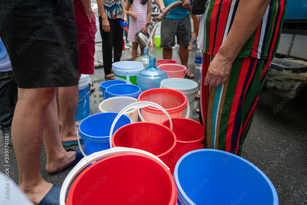 Empty water buckets waiting for fresh water from emergency mobile tank ...