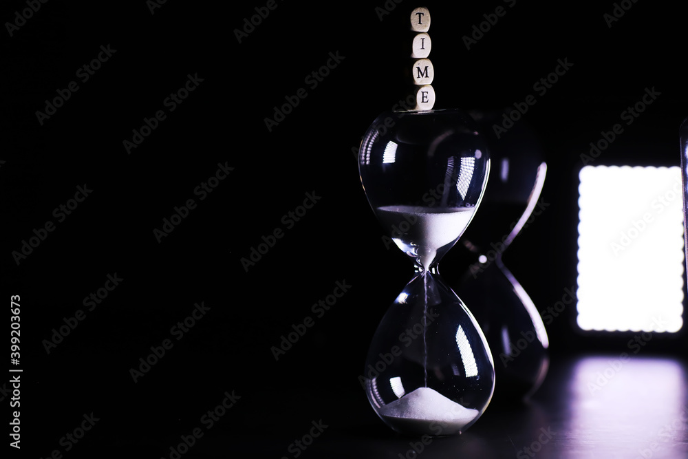 Sand running through the bulbs of an hourglass measuring the passing ...