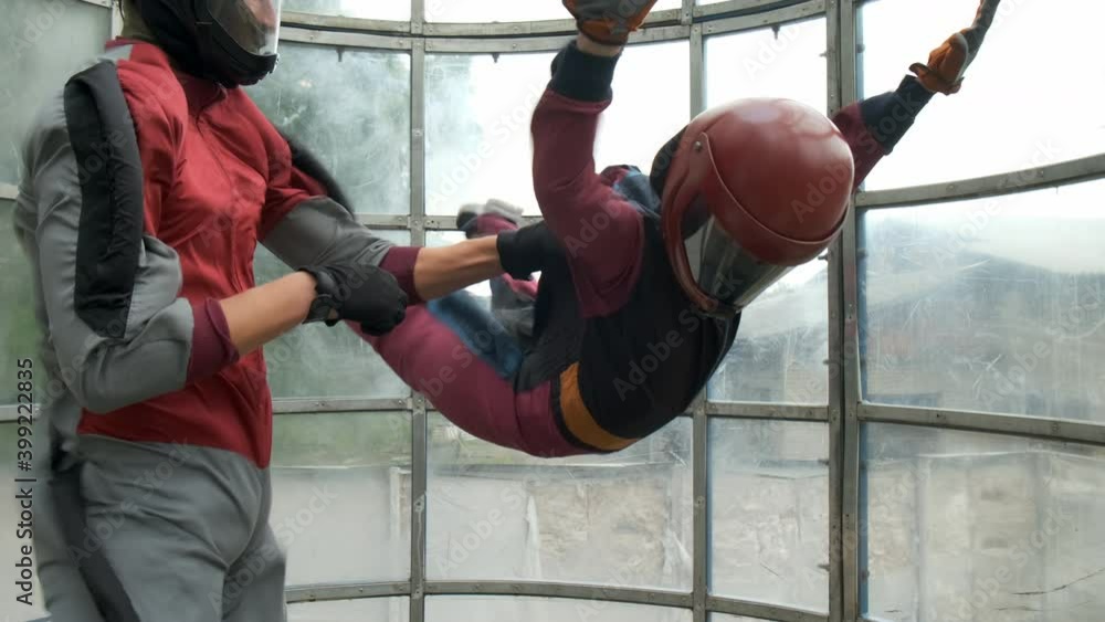 Child boy with man instructor is flying in aerodynamic tube. Instructor ...