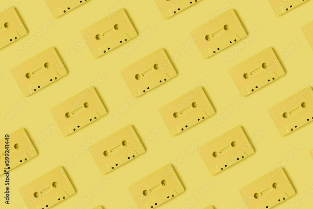 Pattern made with retro audio cassettes on modern yellow background ...