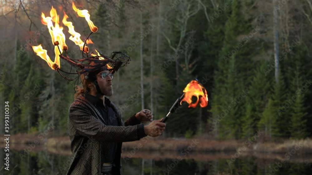 Handsome young male dancer wearing dragon helmet and holding fire stick ...