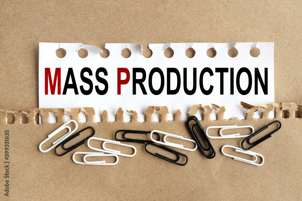 MASS PRODUCTION. Text on white paper on torn paper background Stock ...