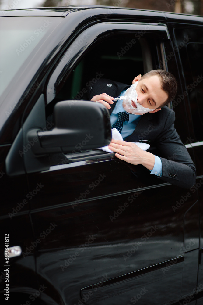 Businessman shaving in car by razor and foam at the wheel. Shaving man ...