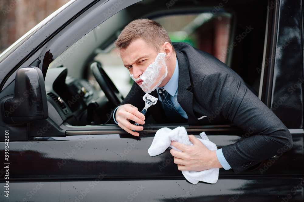 Businessman shaving in car by razor and foam at the wheel. Shaving man ...