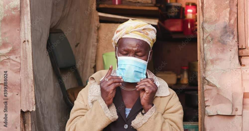 Close-up portrait view of an old Black African woman putting on a ...