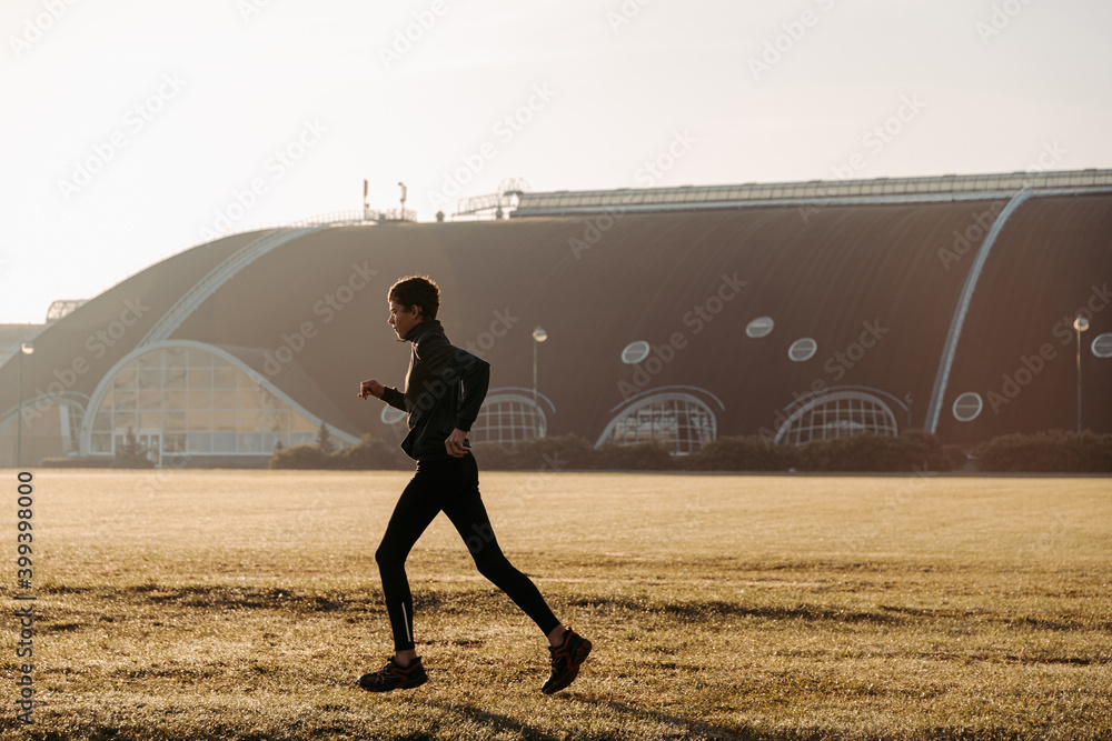 Teen athlete running on field Stock Photo | Adobe Stock