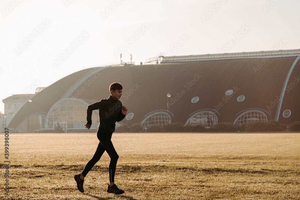 Teen athlete running on field Stock Photo | Adobe Stock