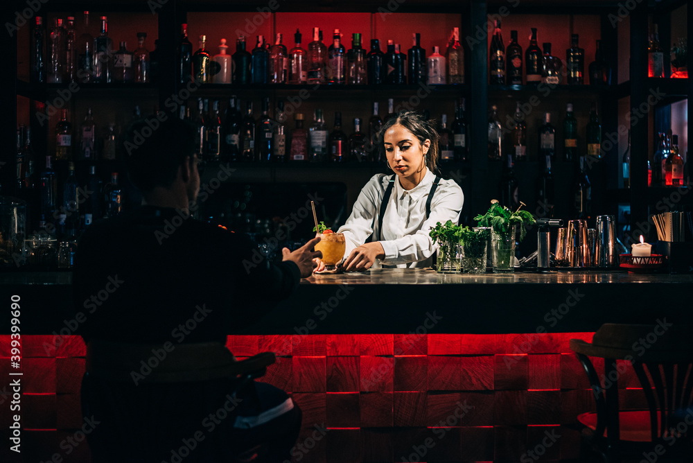 Foto de Female barkeeper serving cocktail to anonymous customer do ...