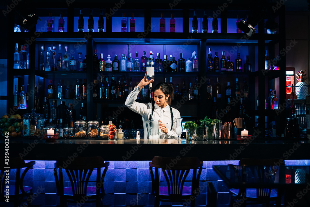 Female mixologist pouring liquor in bottle Stock Photo | Adobe Stock