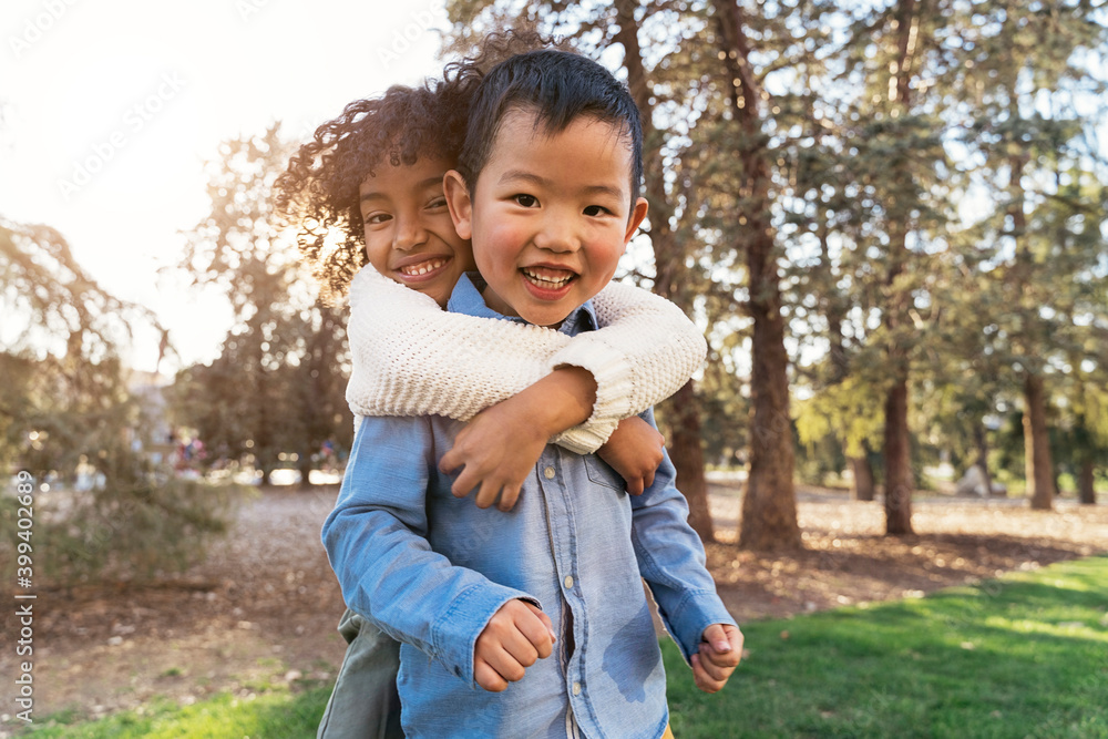 Multiethnic children hugging at the park. Stock Photo | Adobe Stock
