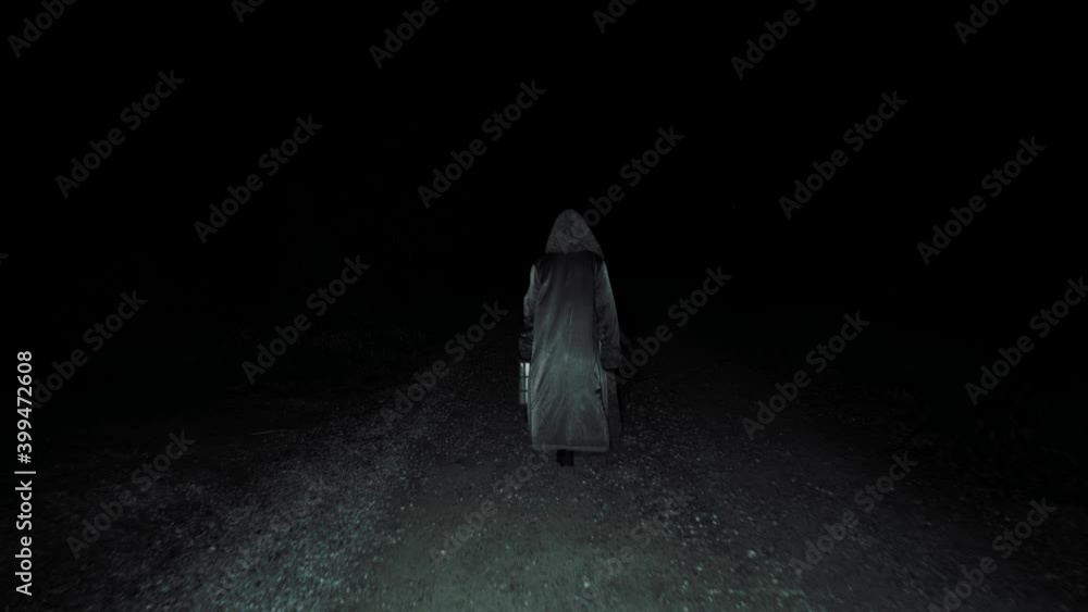 Old witch walking down dark spooky road. Scary old woman moving through ...