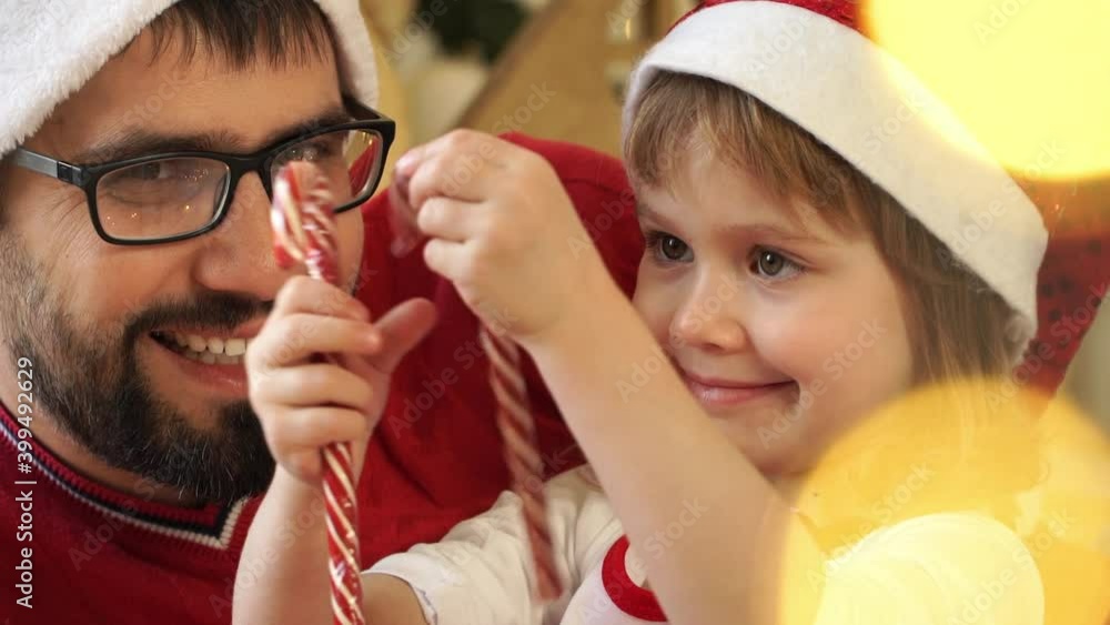 Close up of happy young father with little child girl in red santa hats ...