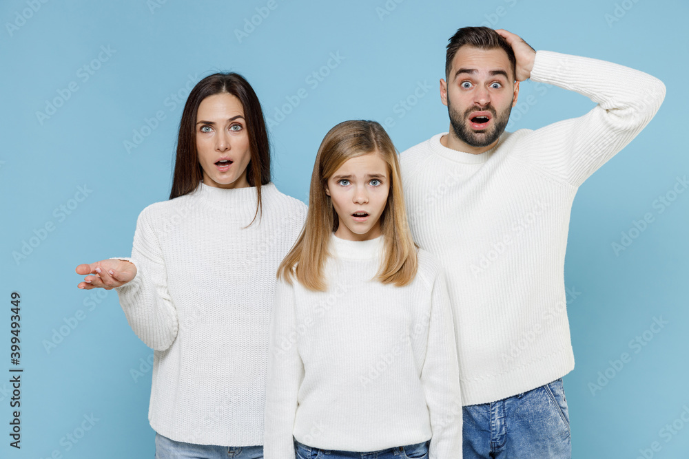 Puzzled worried young parents mom dad with child kid daughter teen girl in basic white sweaters ...