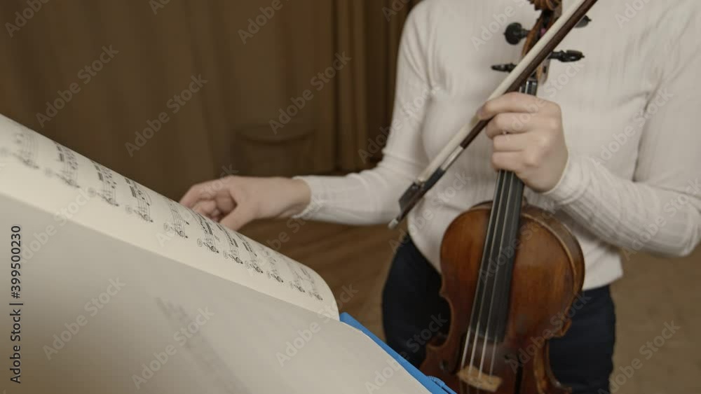 Female hand violinist flip through notes on music stand, background ...