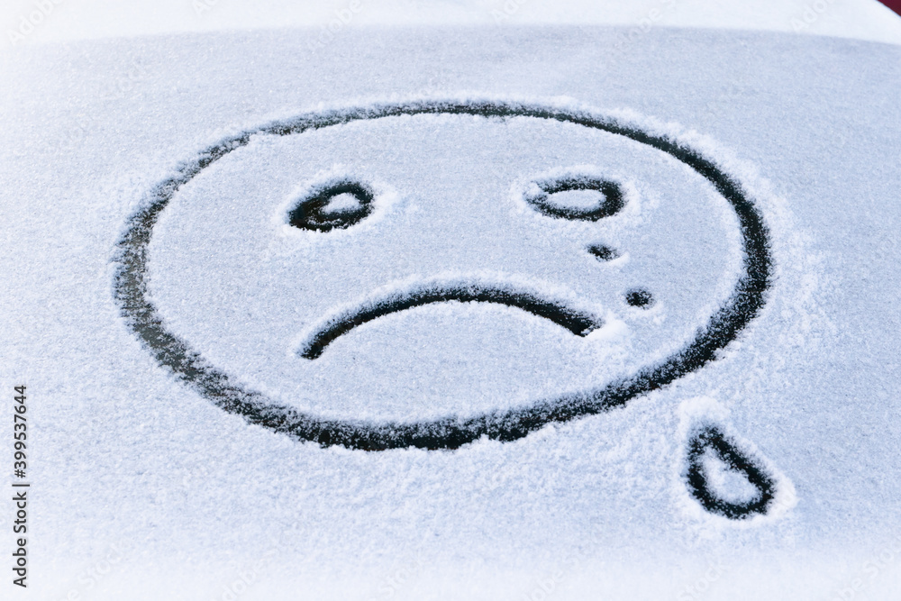image of a crying face emoji on the snow on the back window of a car on ...
