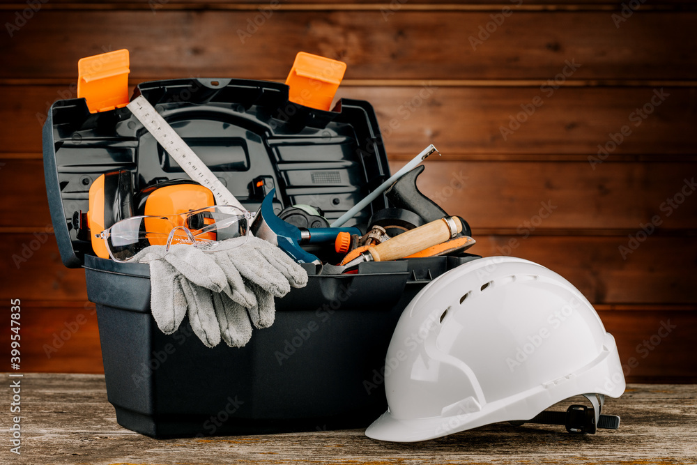 Open plastic tool kit box with construction safety helmet and various ...