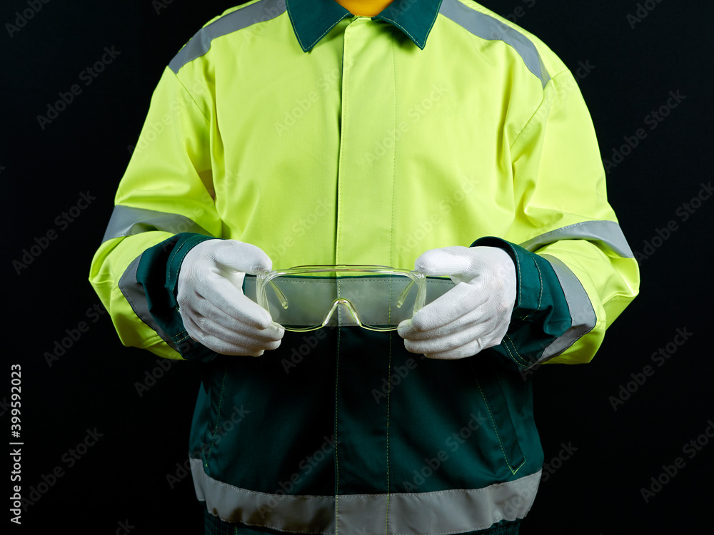 A worker holds safety glasses in his hands. Safety at work, vision ...