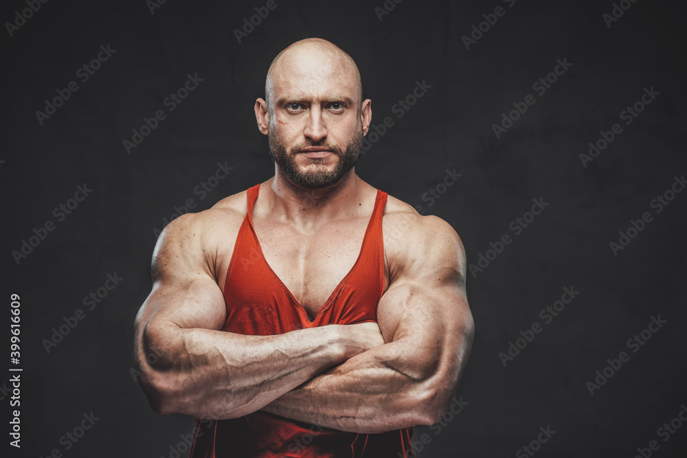 Powerful and hairless guy in red shirt with beard and strong hands ...